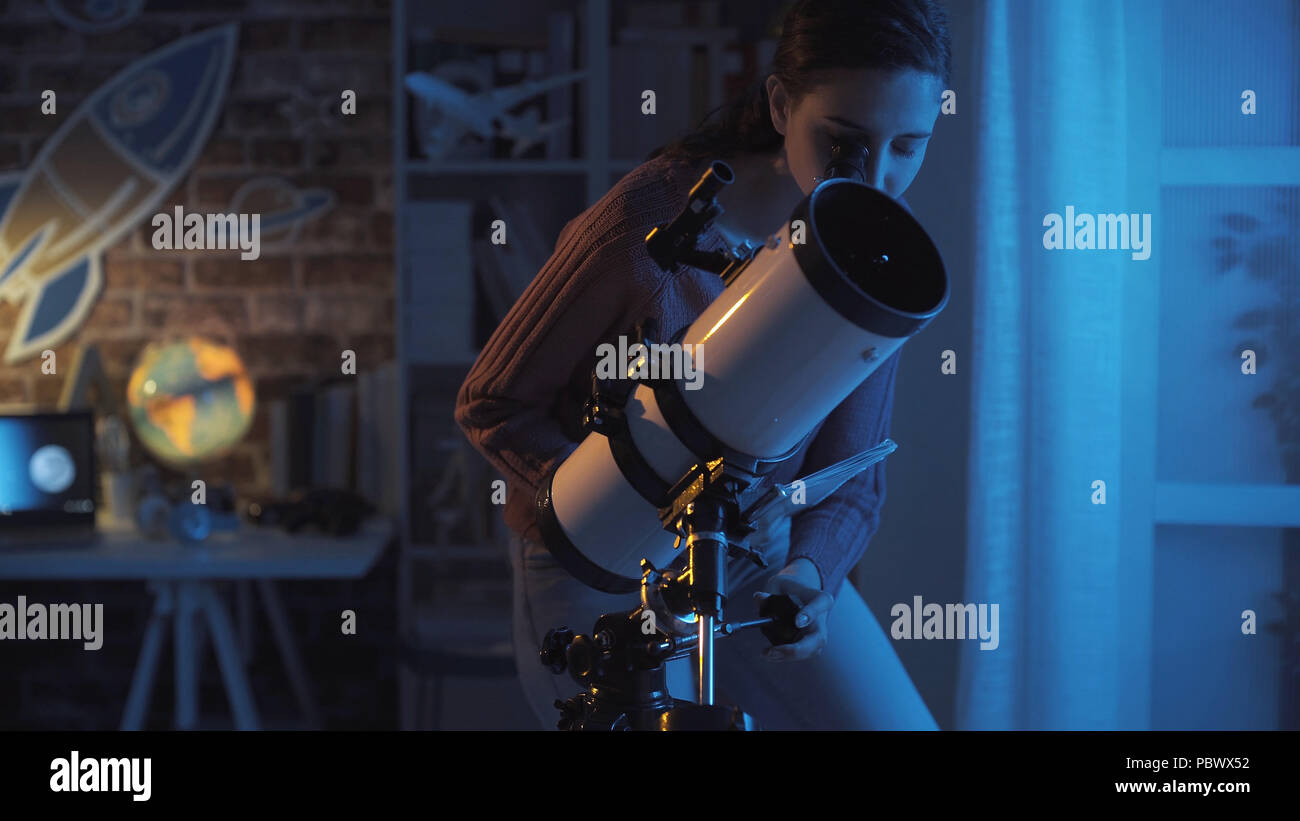 Young smart woman studying astronomy and watching the stars using a ...