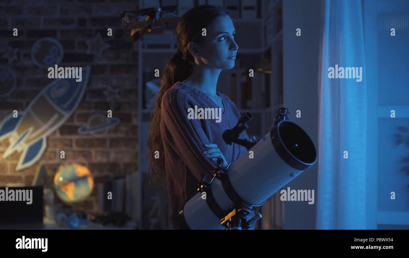 Young smart woman studying astronomy and watching the stars using a ...