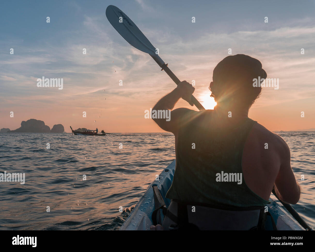 Kayaking. Man With kayak paddle at sunset sea Rowing to the Sun Stock ...