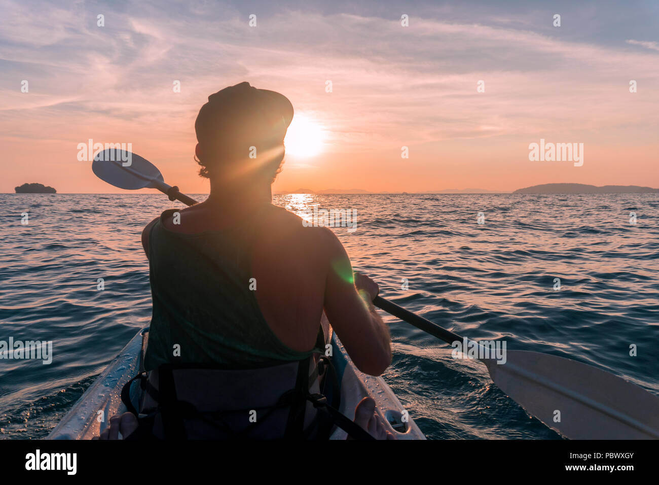 Kayaking. Man With kayak paddle at sunset sea Rowing to the Sun Stock ...