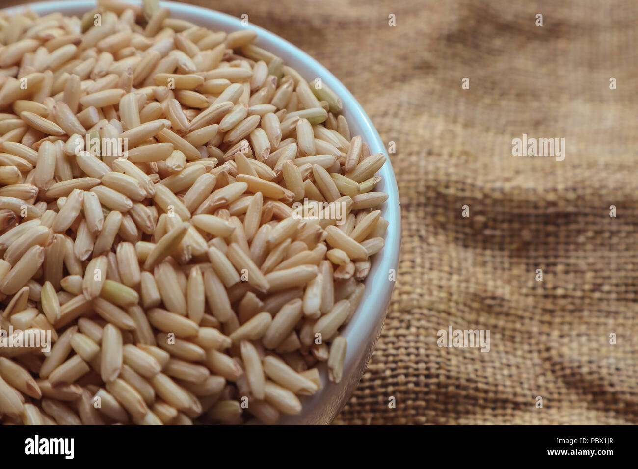 Raw brown rice in a bowl. top view food background Stock Photo - Alamy