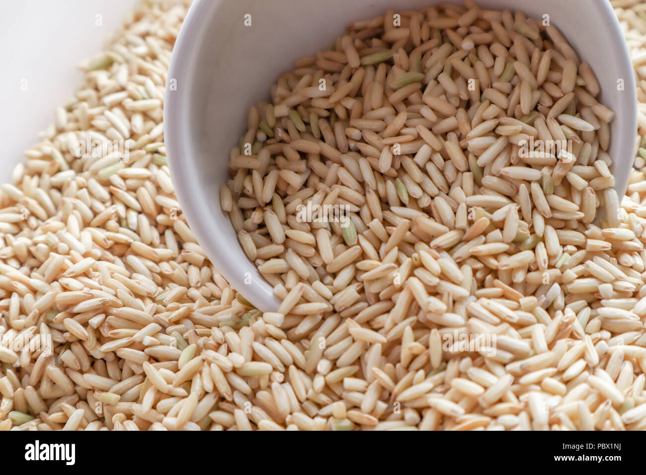 Raw brown rice in a bowl. top view food background Stock Photo - Alamy