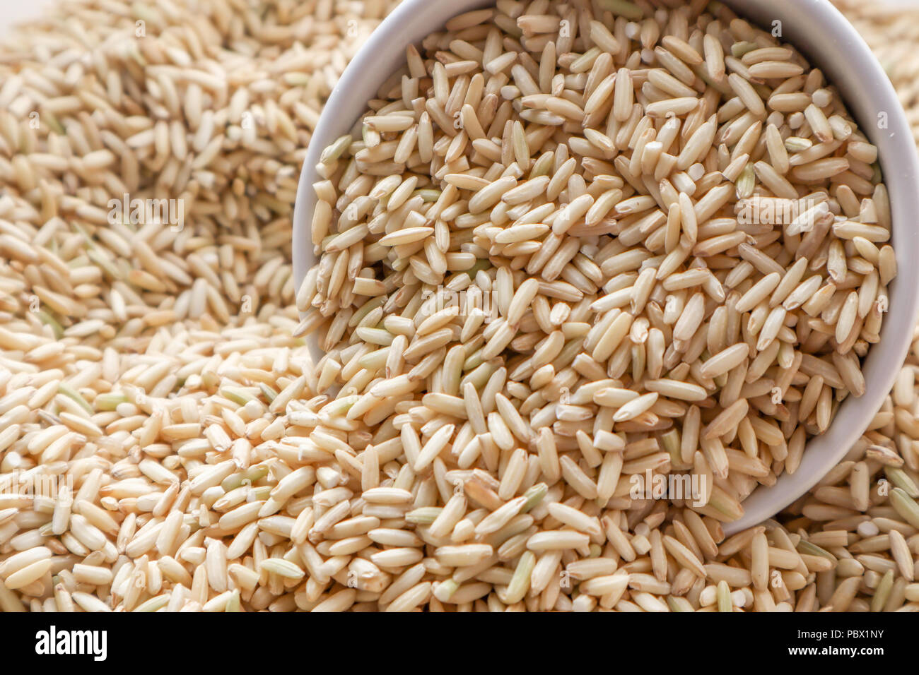 Raw brown rice in a bowl. top view food background Stock Photo - Alamy