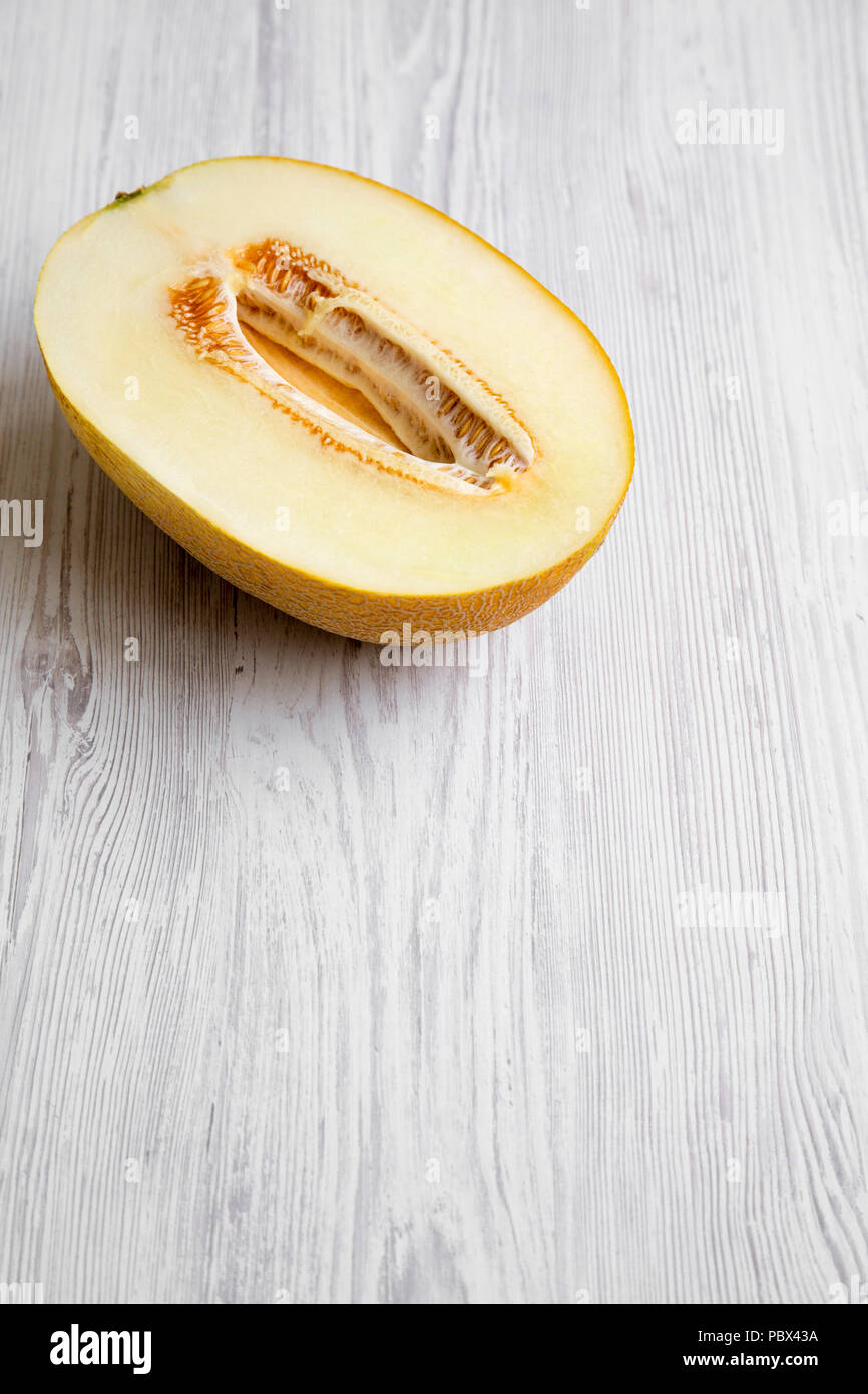 Half of melon on white wooden background Stock Photo - Alamy