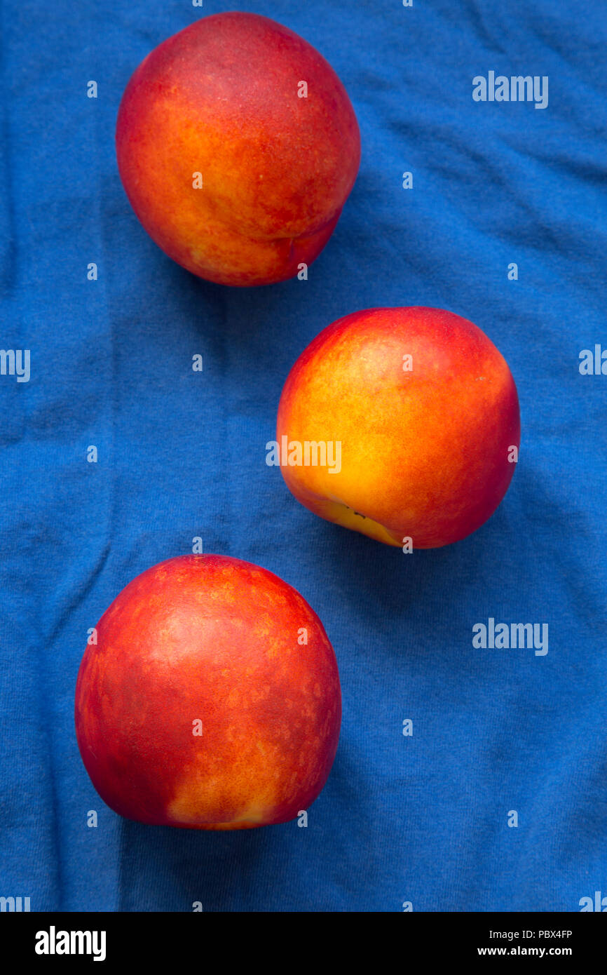 Nectarines on a blue cloth, top view Stock Photo - Alamy