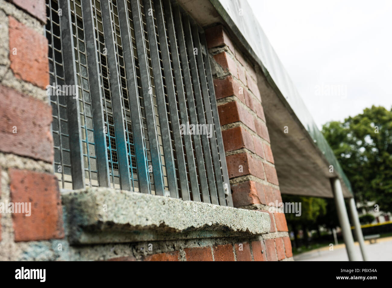 fenced off window on orange brick wall Stock Photo - Alamy