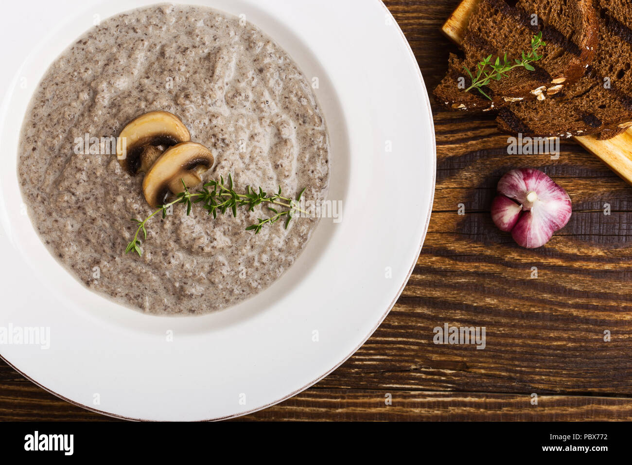 Cream of mushroom soup with ray bread toasts on wooden table, top view ...