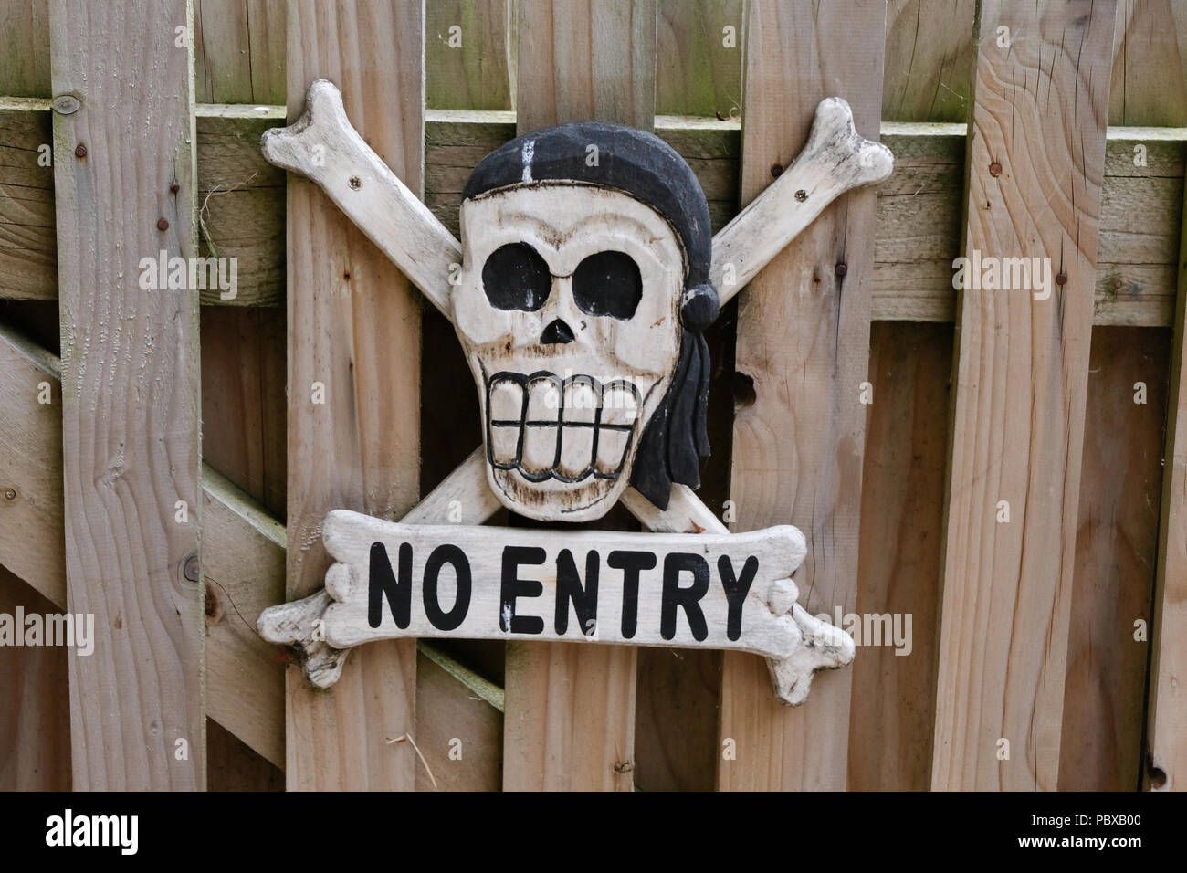 Quirky skull and crossbones street sign on a gate at Robin Hoods Bay on ...