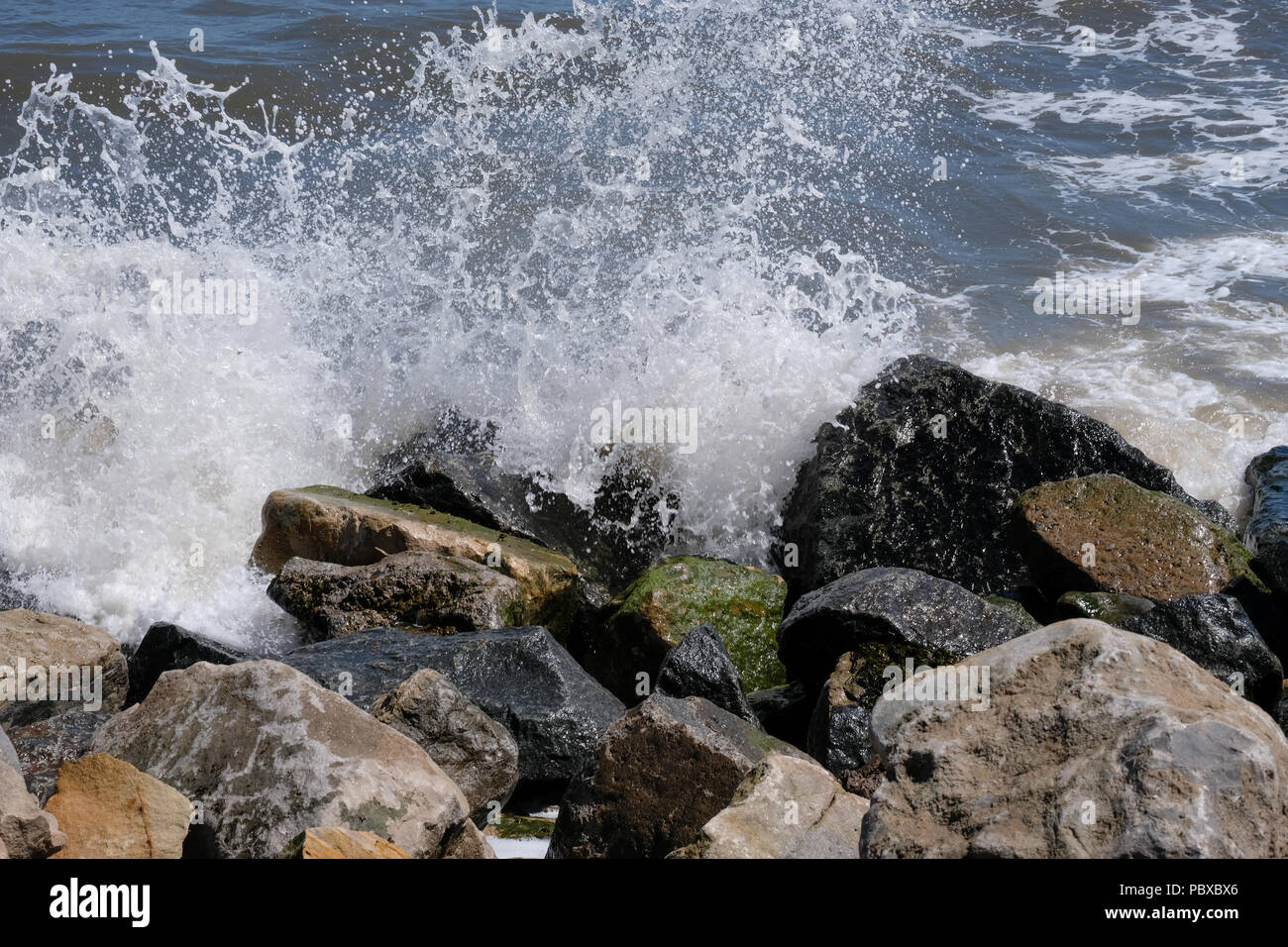 Concept close up images of waves washing over rocks and splashing up ...