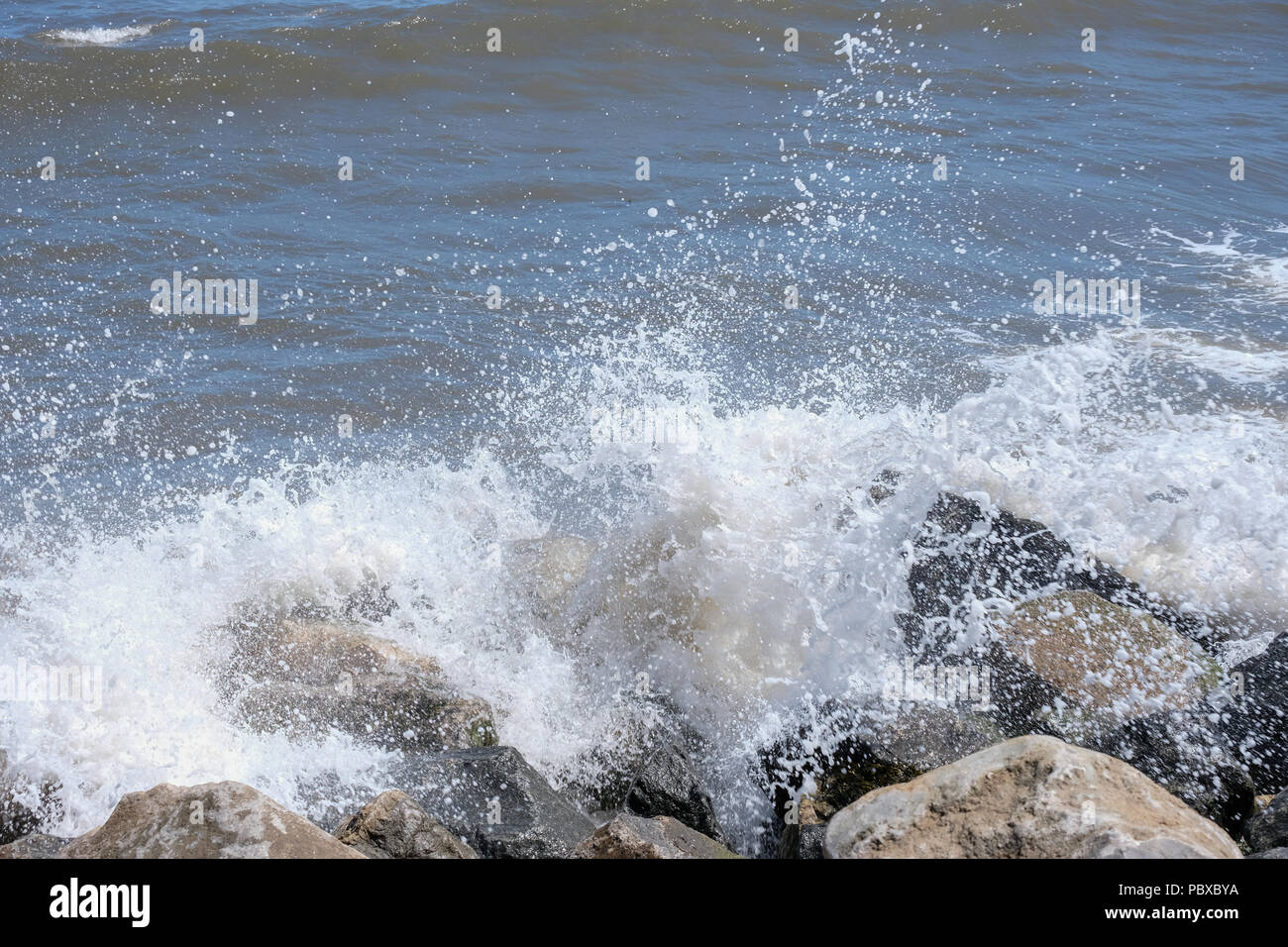Concept close up images of waves washing over rocks and splashing up ...