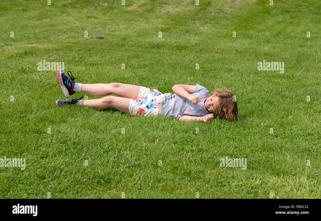 Children playing at rolling down a grassy hillside Stock Photo - Alamy