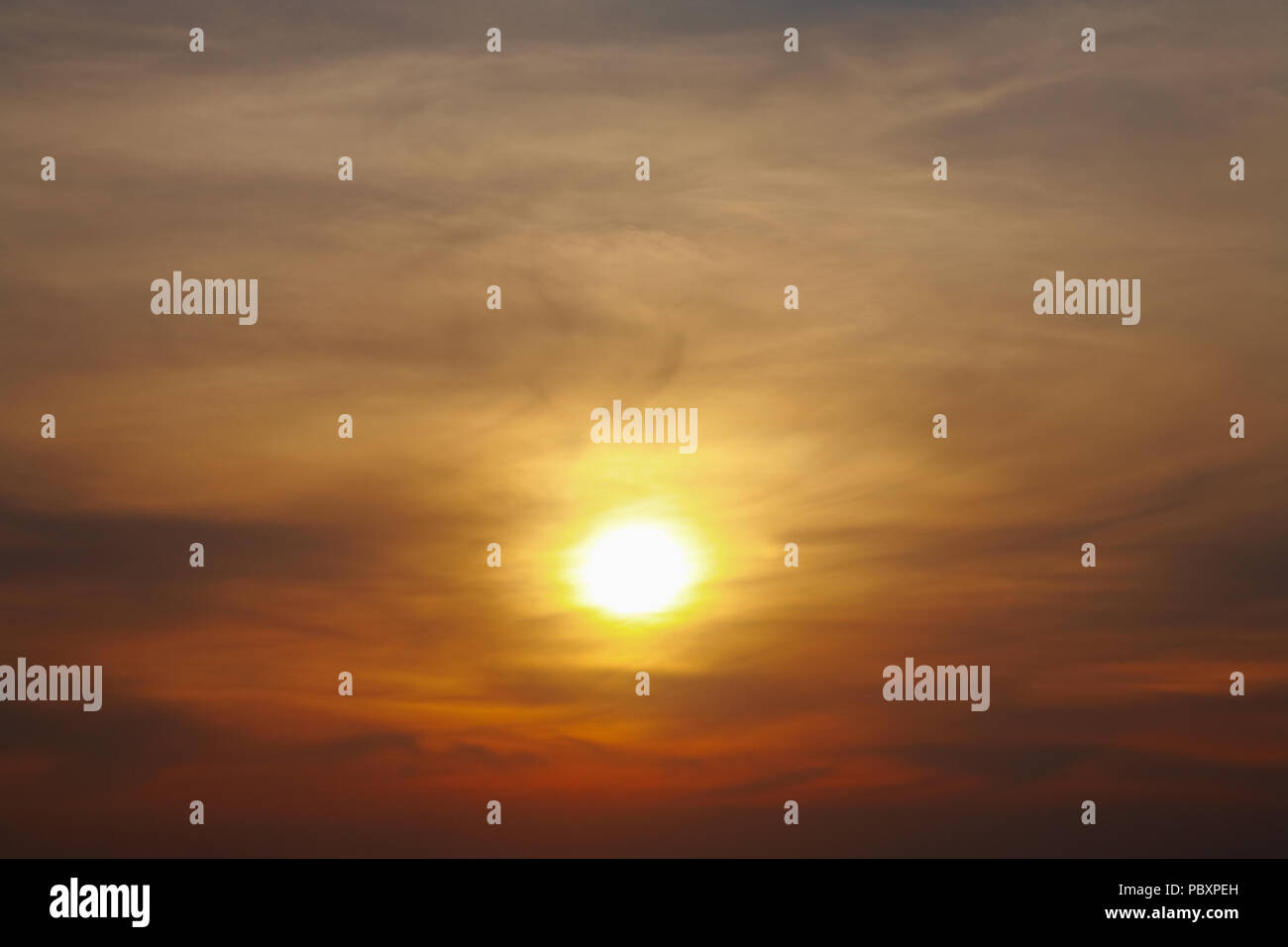 Sun behind the clouds at sunset Stock Photo - Alamy