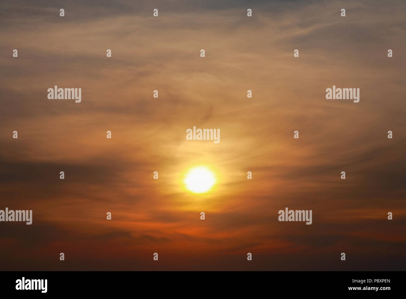 Sun behind the clouds at sunset Stock Photo - Alamy