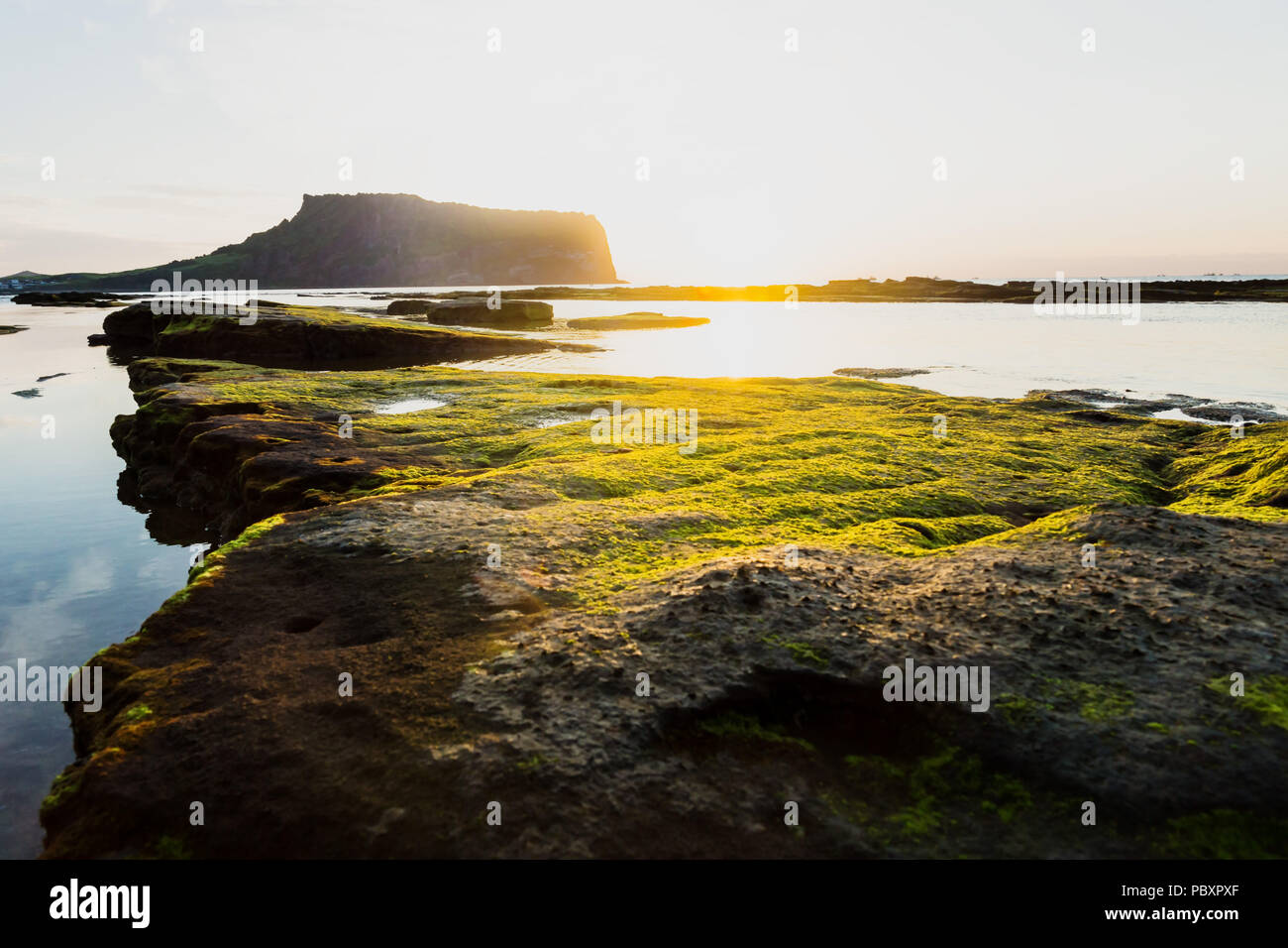 First sunrays at sunrise at Ilchulbong volcano crater with view over ...