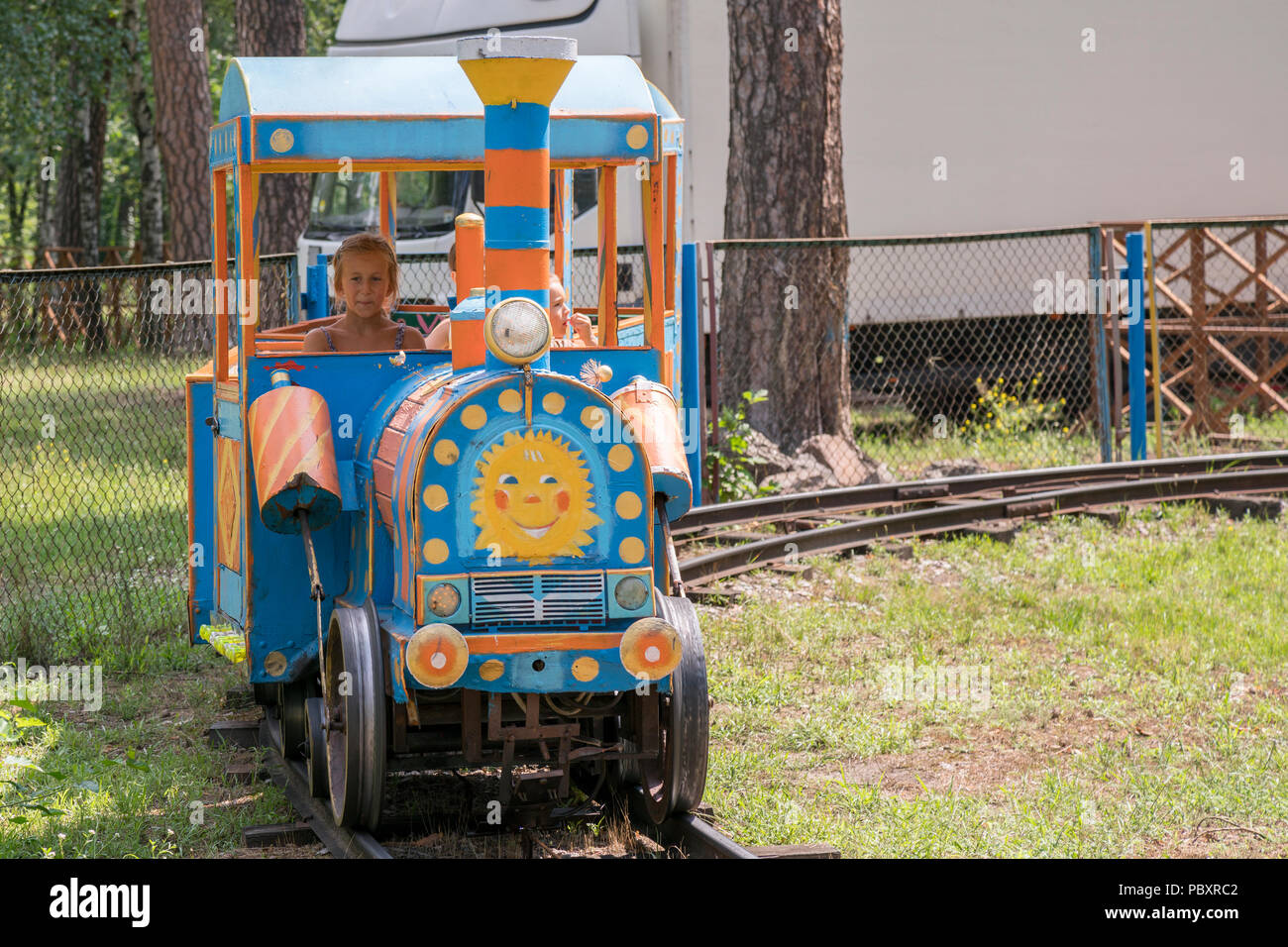 children are riding on a children's train in the park Stock Photo - Alamy