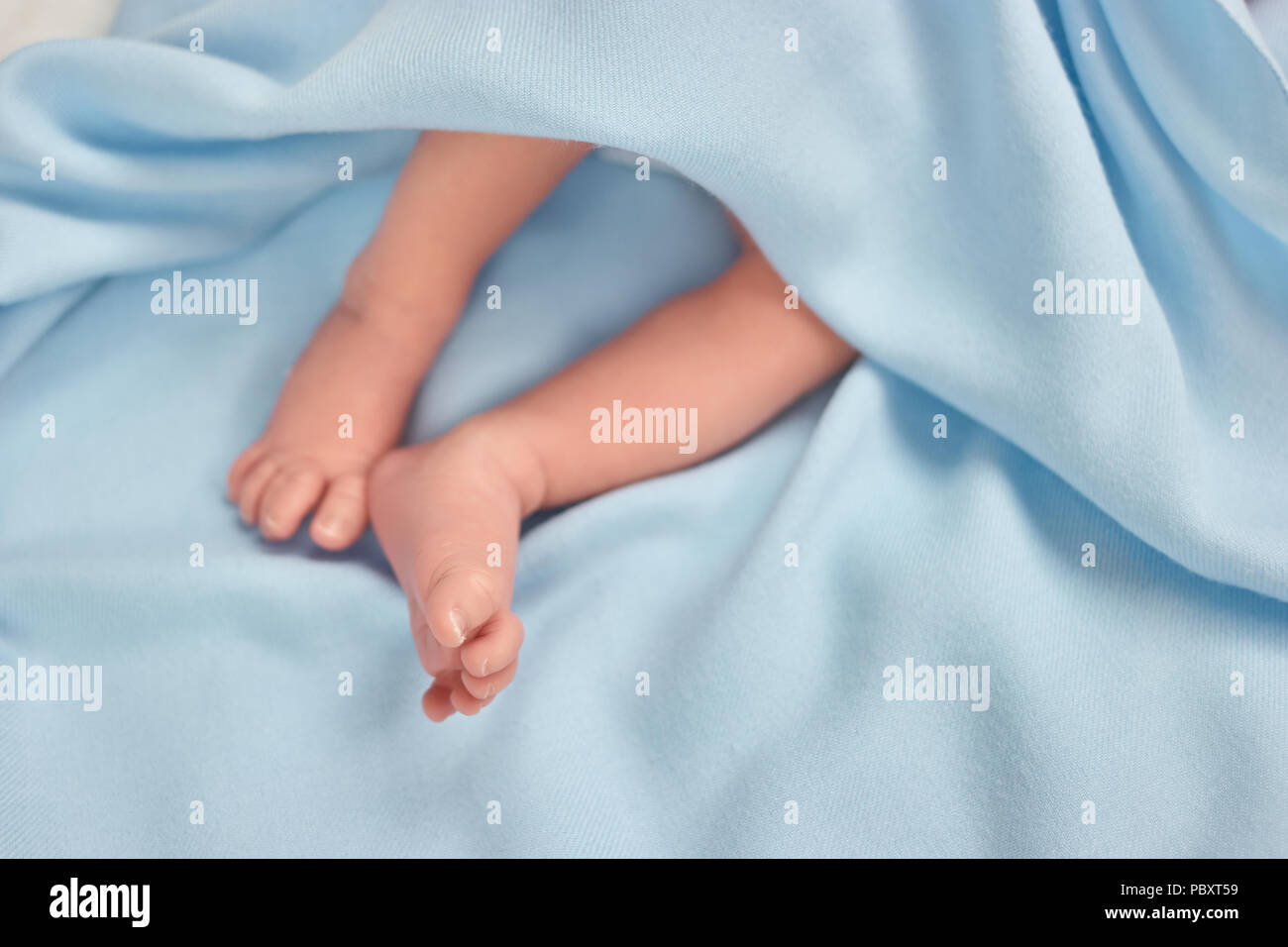 Newborn baby boy legs. Soft blue blanket Stock Photo - Alamy