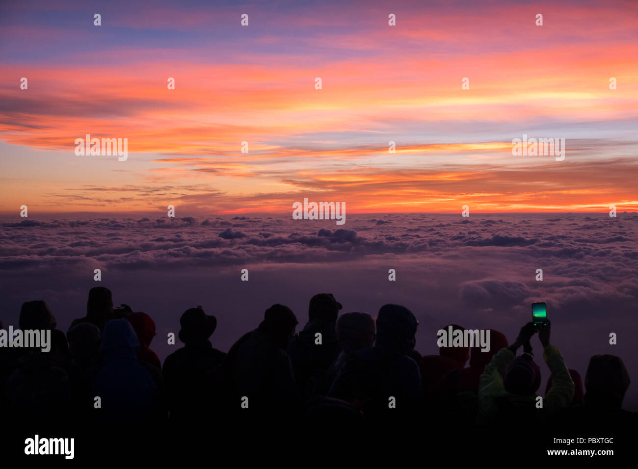 Climbers watch a spectacular sunrise at the summit of Mount Fuji in ...