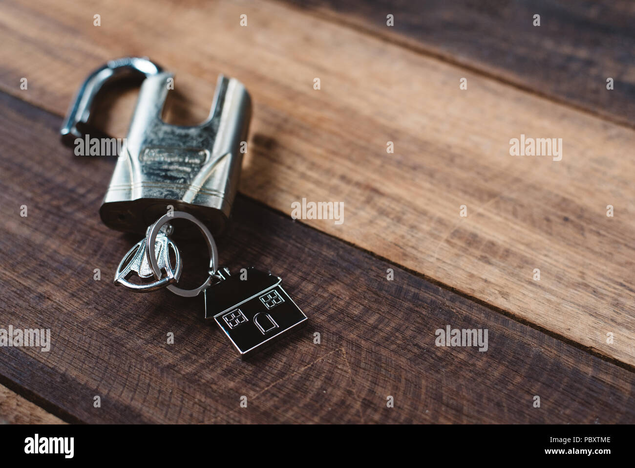 lock, key and house shape key tag on wooden table. house security and ...