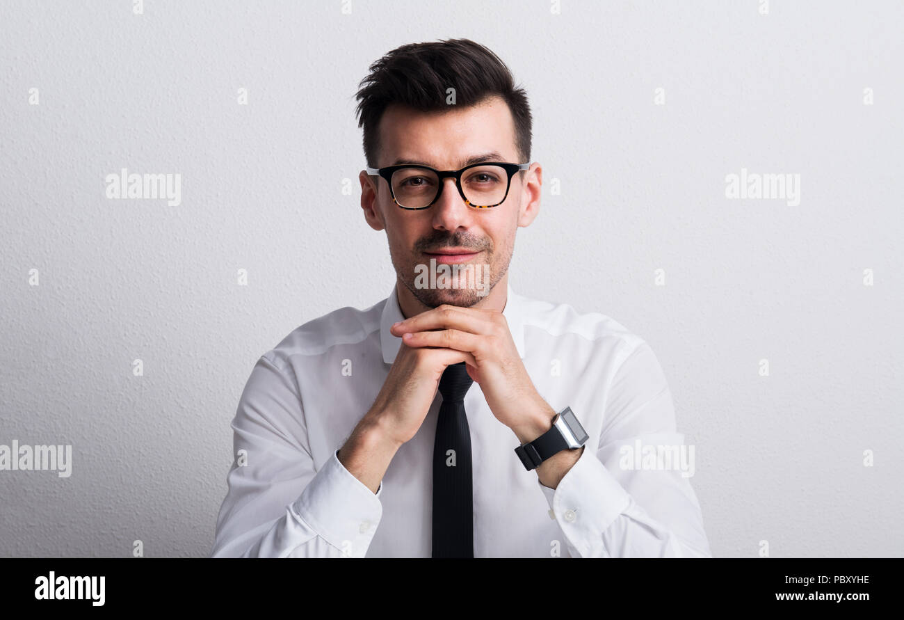 Portrait of a young man in a studio, resting chin on his hands Stock ...