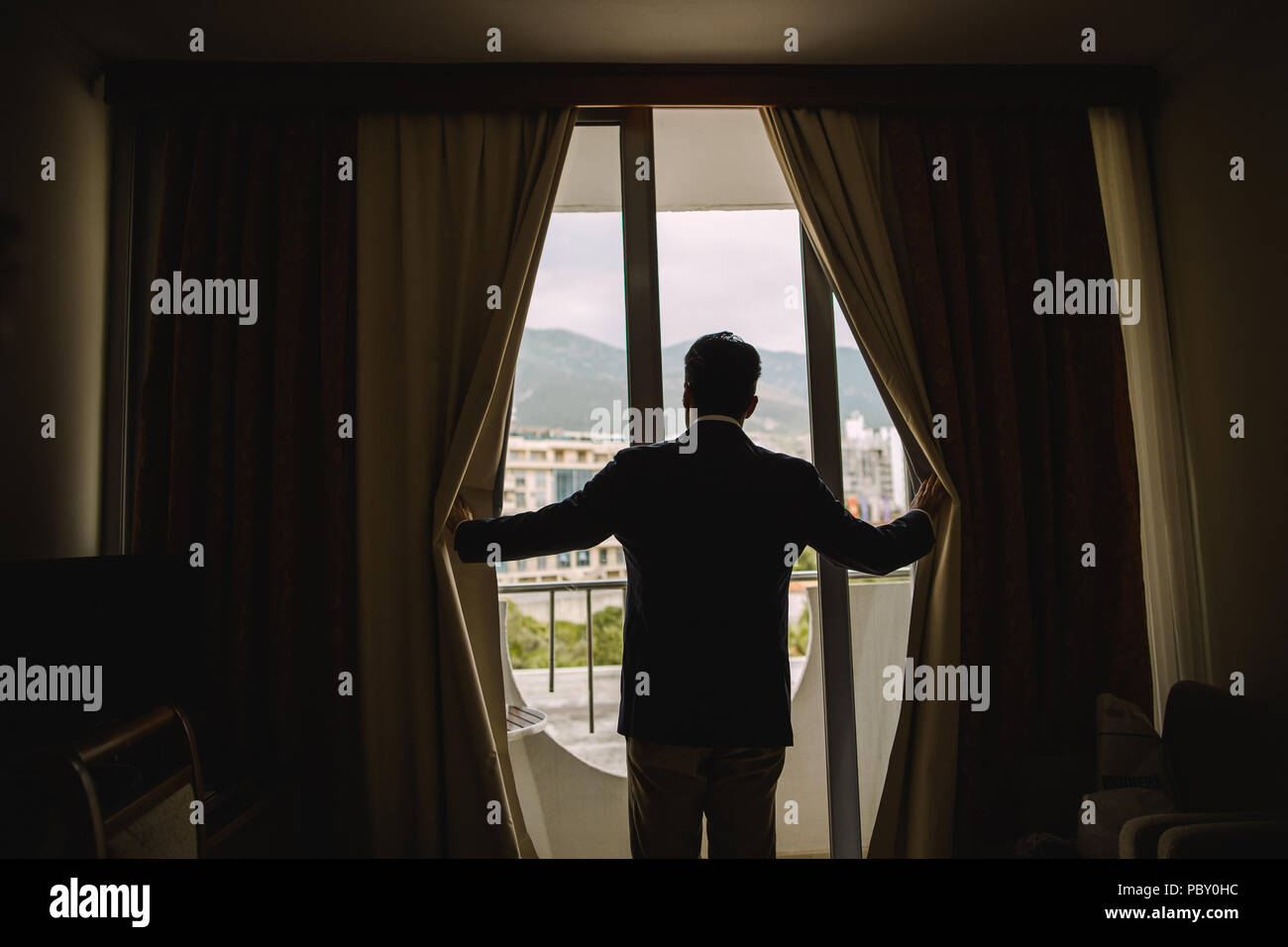 man looking at window in hotel Stock Photo - Alamy
