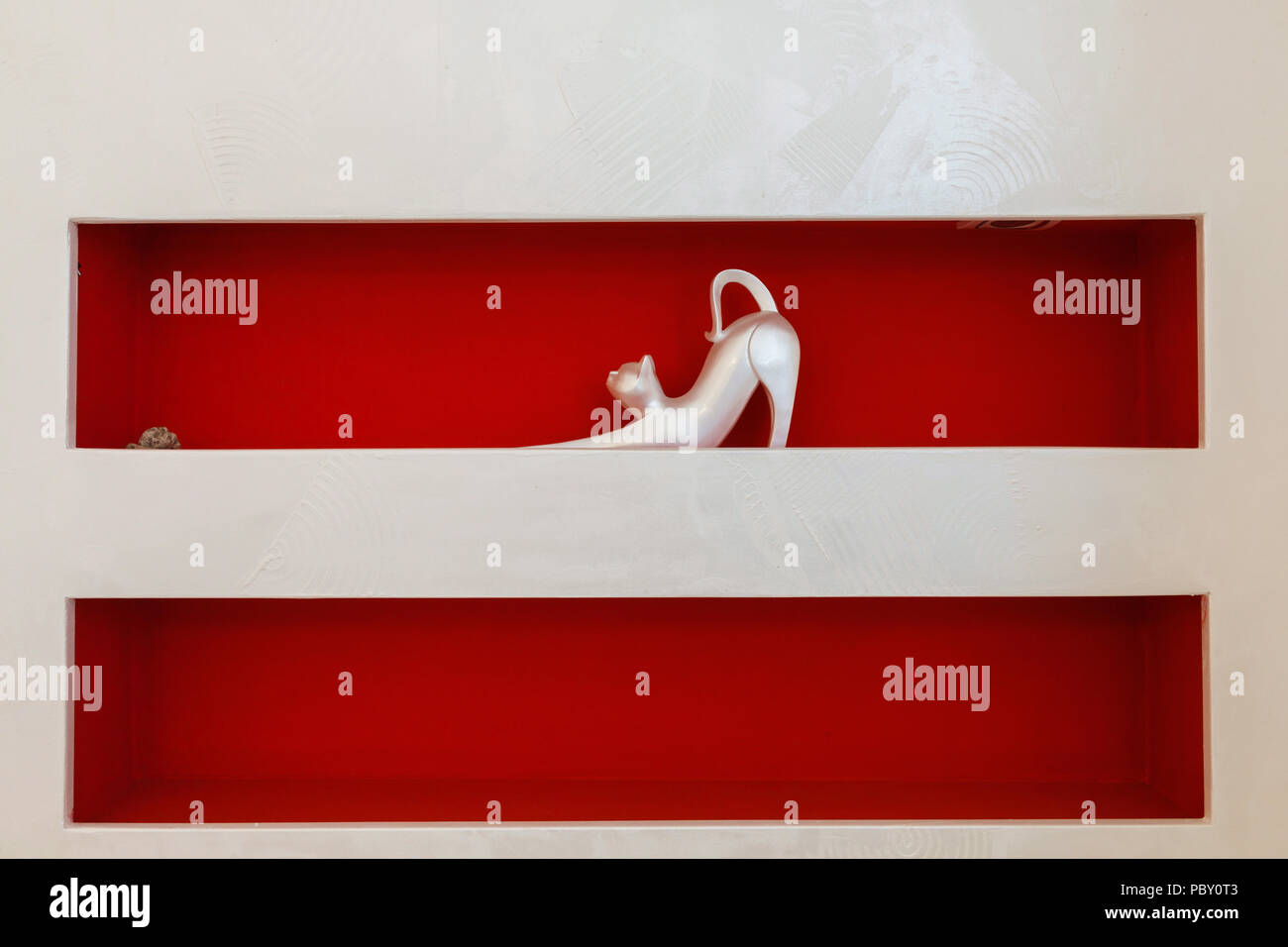 double red niche with a miniature sculpture of a cat Stock Photo - Alamy