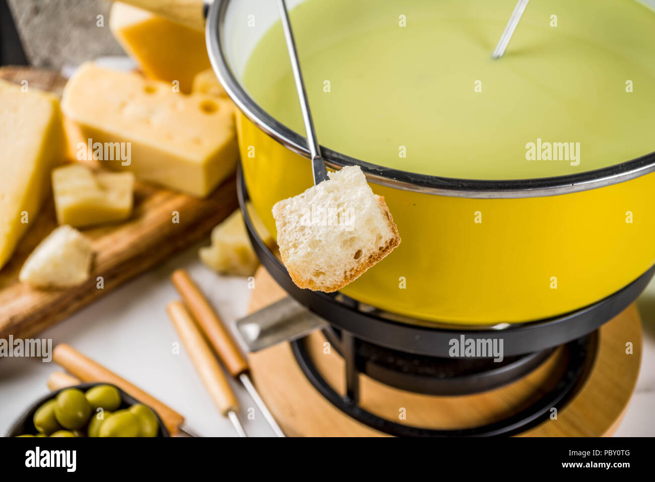 Gourmet Swiss fondue in traditional fondue pot, with forks, various ...