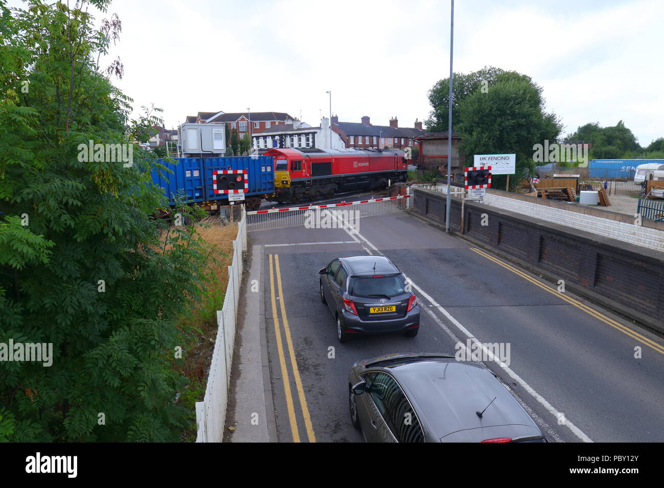 A freight train passes over a level crossing between High Street ...