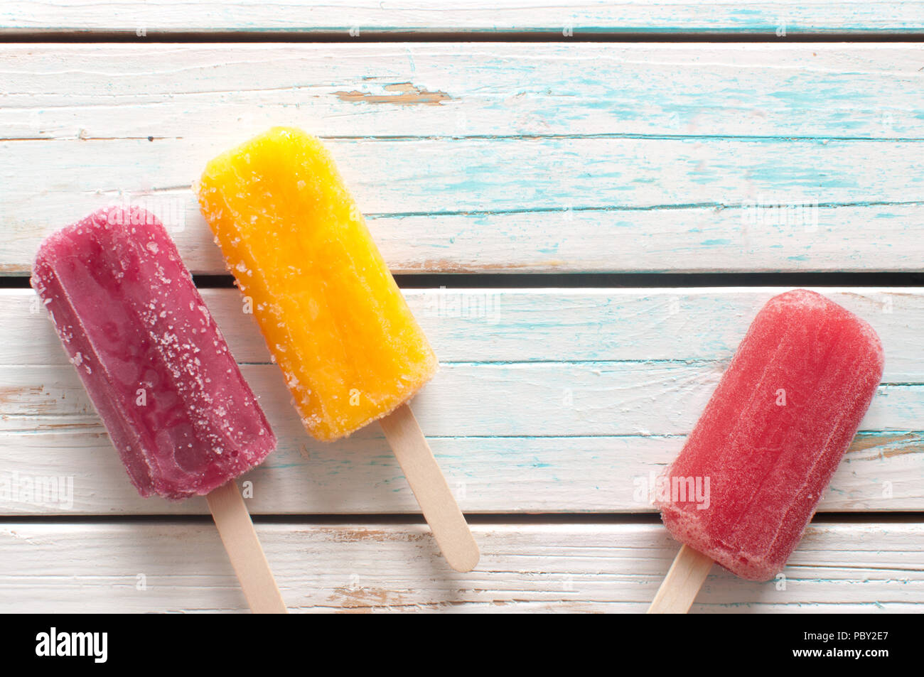 Frozen ice popsicles various flavors on wooden background Stock Photo ...