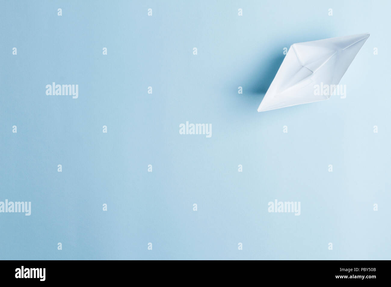 Paper boat on light blue background Stock Photo - Alamy