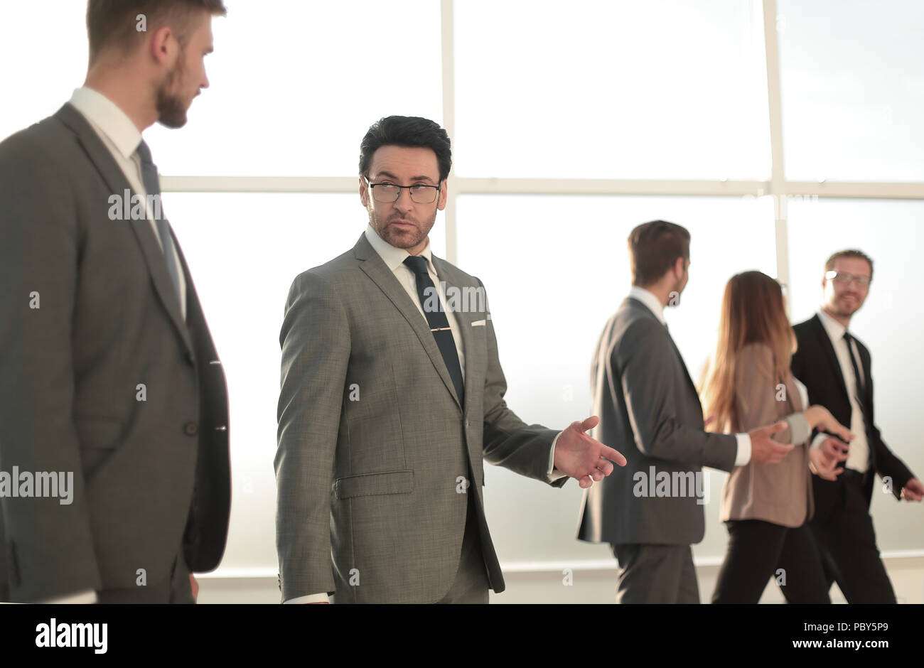 Two businesspeople walking in corridor talking Stock Photo - Alamy