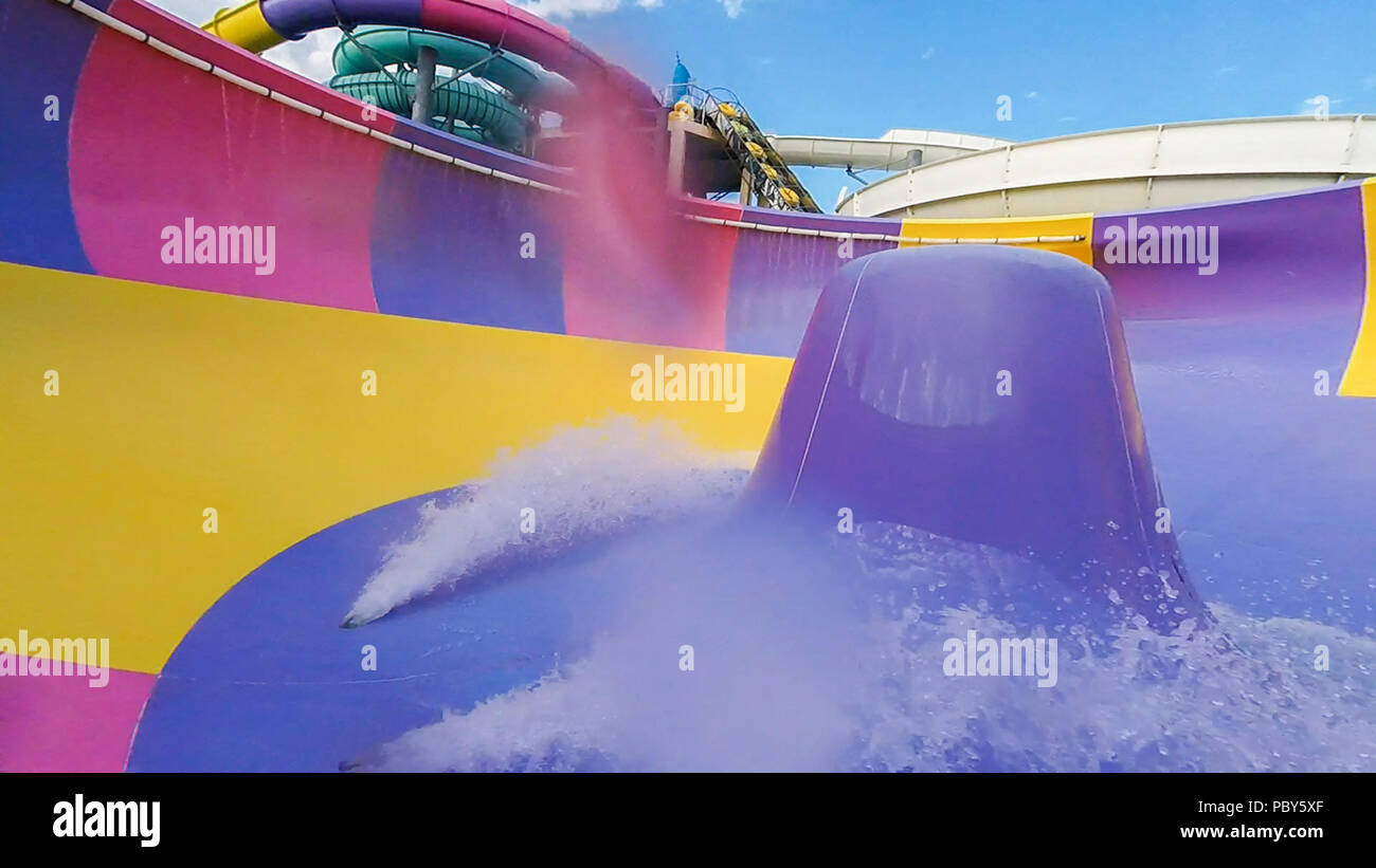 Water color attraction slide with water splashes in an outdoor water ...