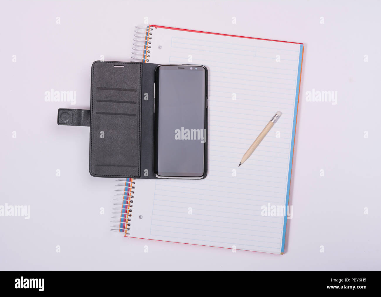 Mobile phone, pencil and notebook isolated on white background Stock ...