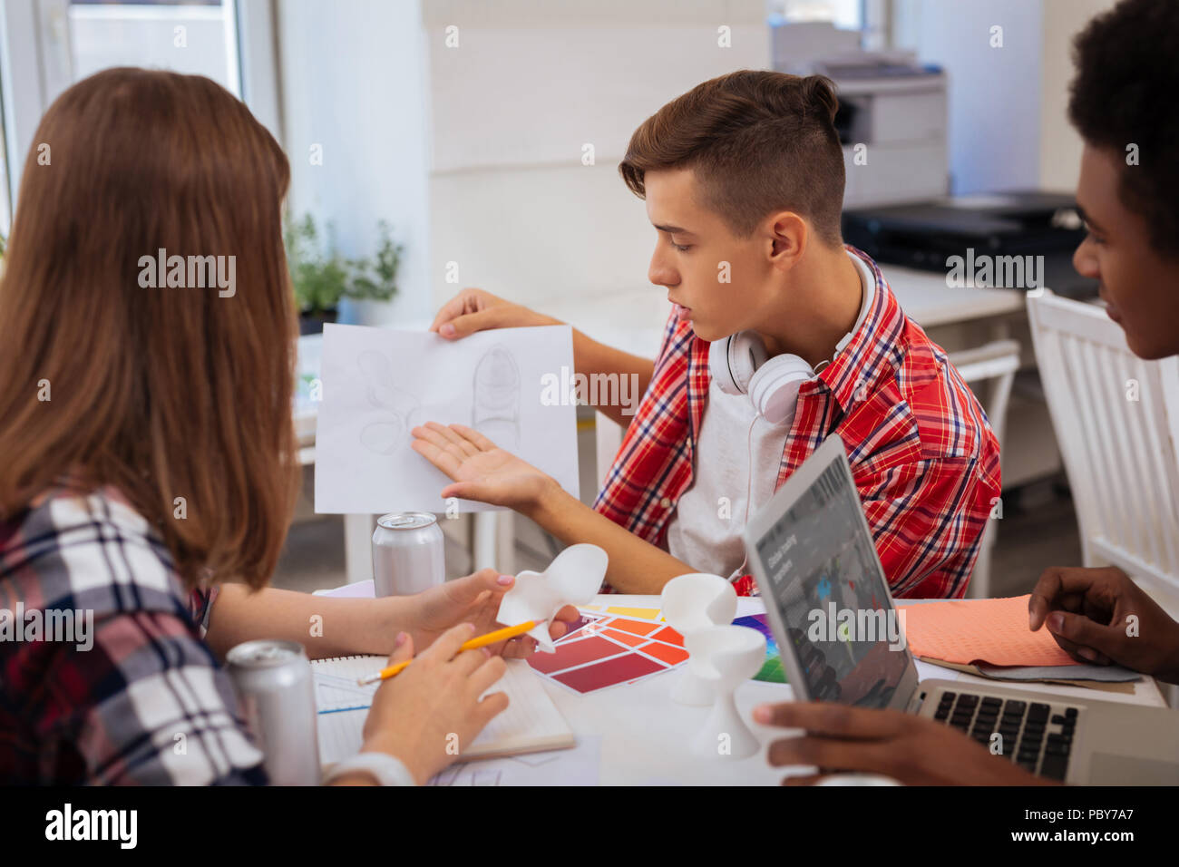 Three young promising interior designers having discussion Stock Photo ...