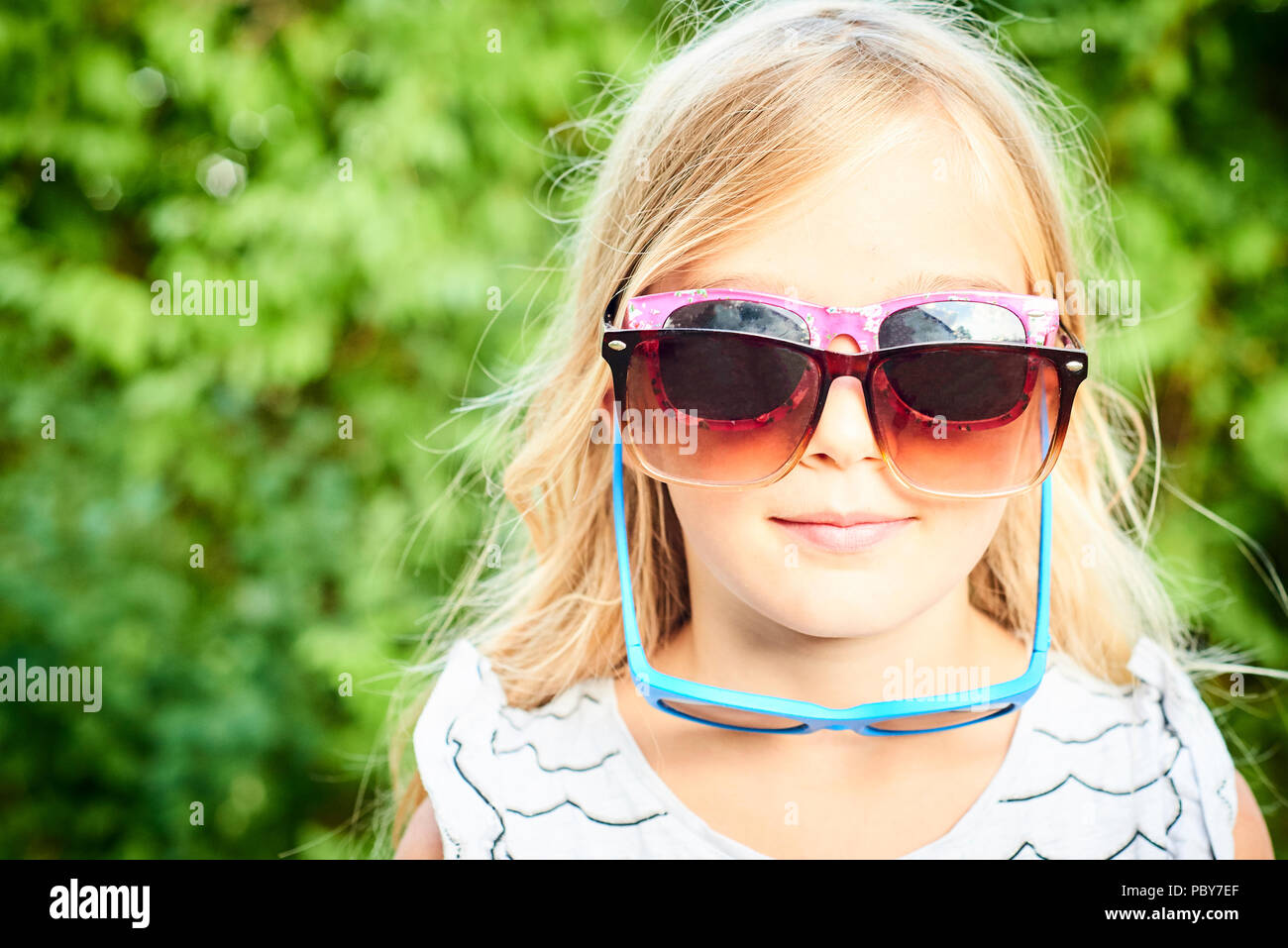 Child cute girl having several sunglasses on her face and doing fun ...