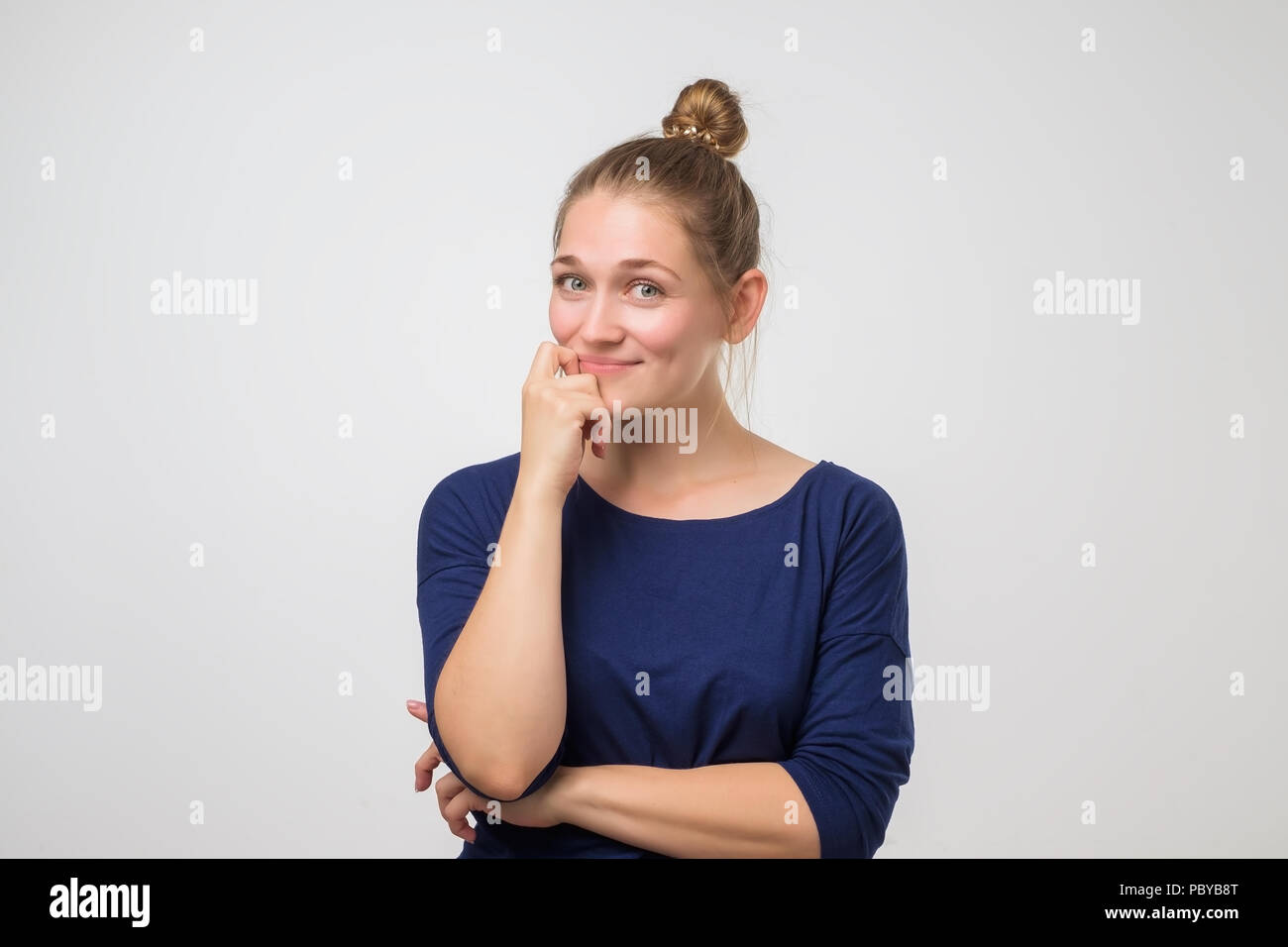 Stylish european woman with hair knot smiling and looking at camera ...
