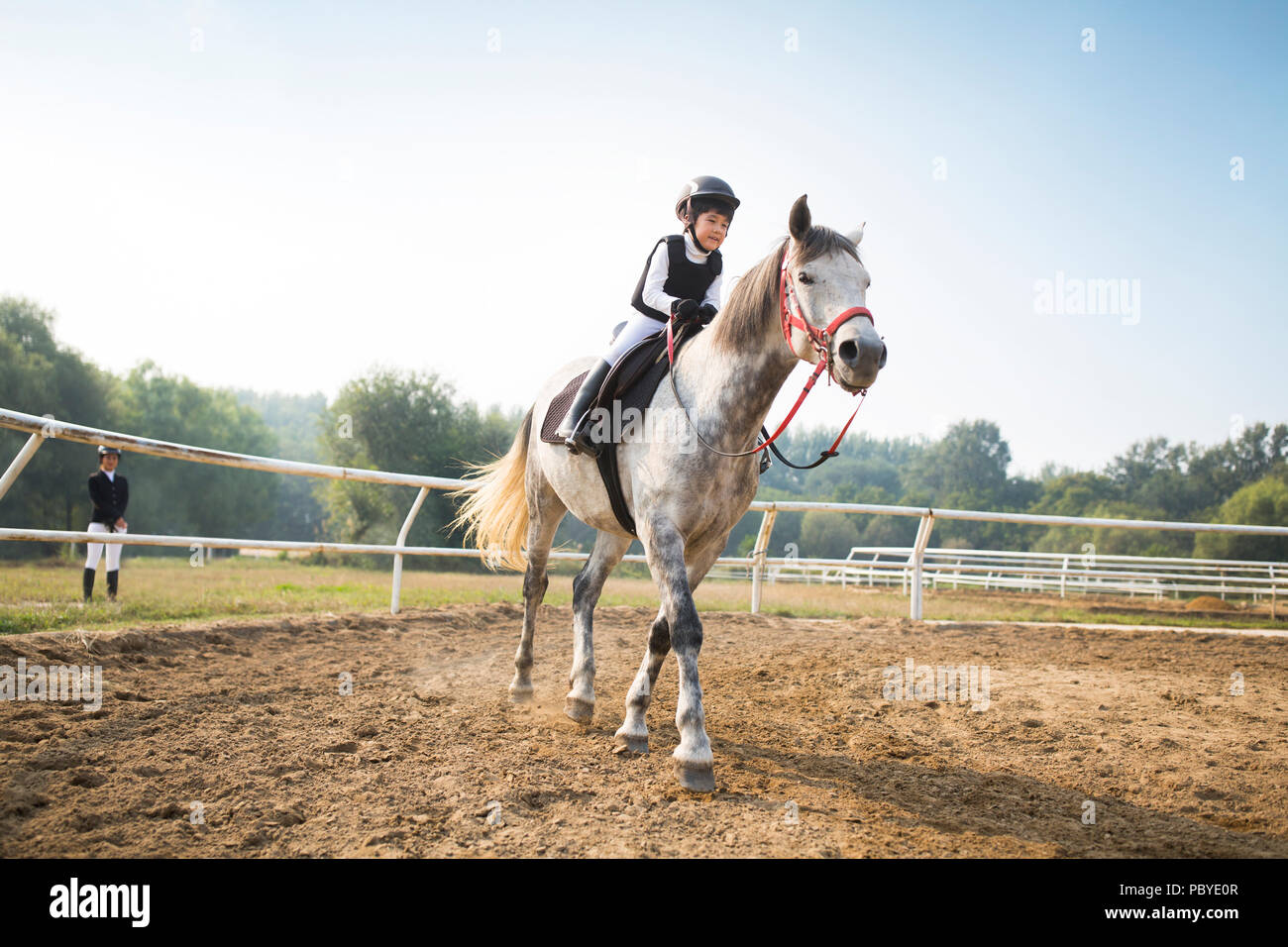 Cheerful little Chinese boy riding horse Stock Photo - Alamy