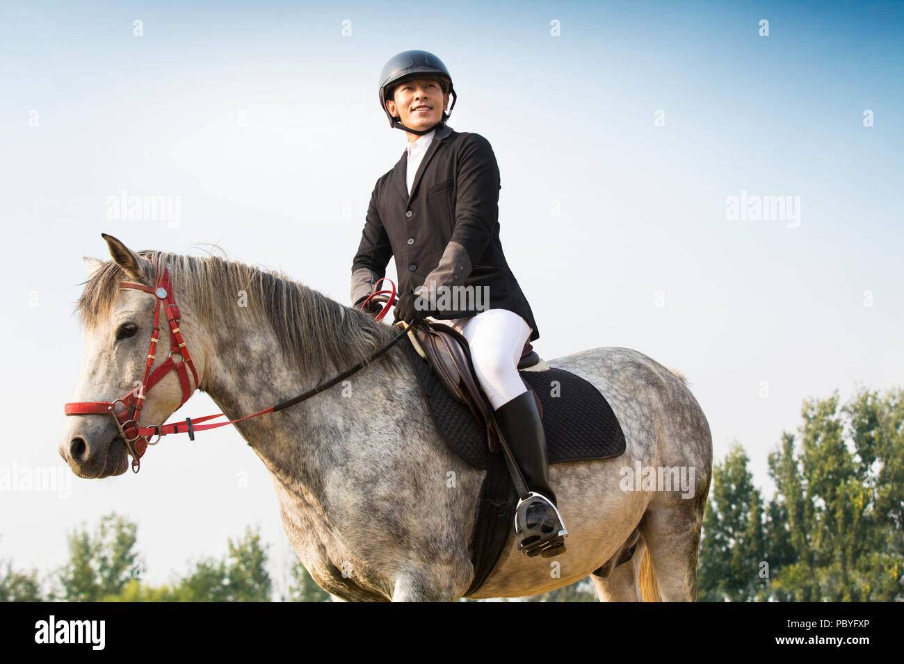 Young Chinese man riding horse Stock Photo - Alamy