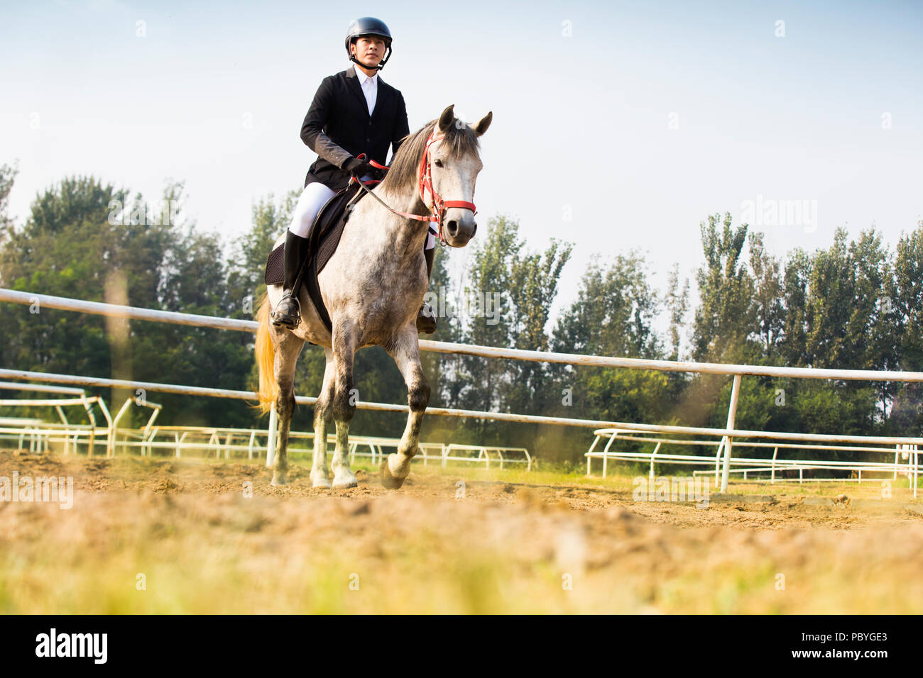 Young Chinese man riding horse Stock Photo - Alamy
