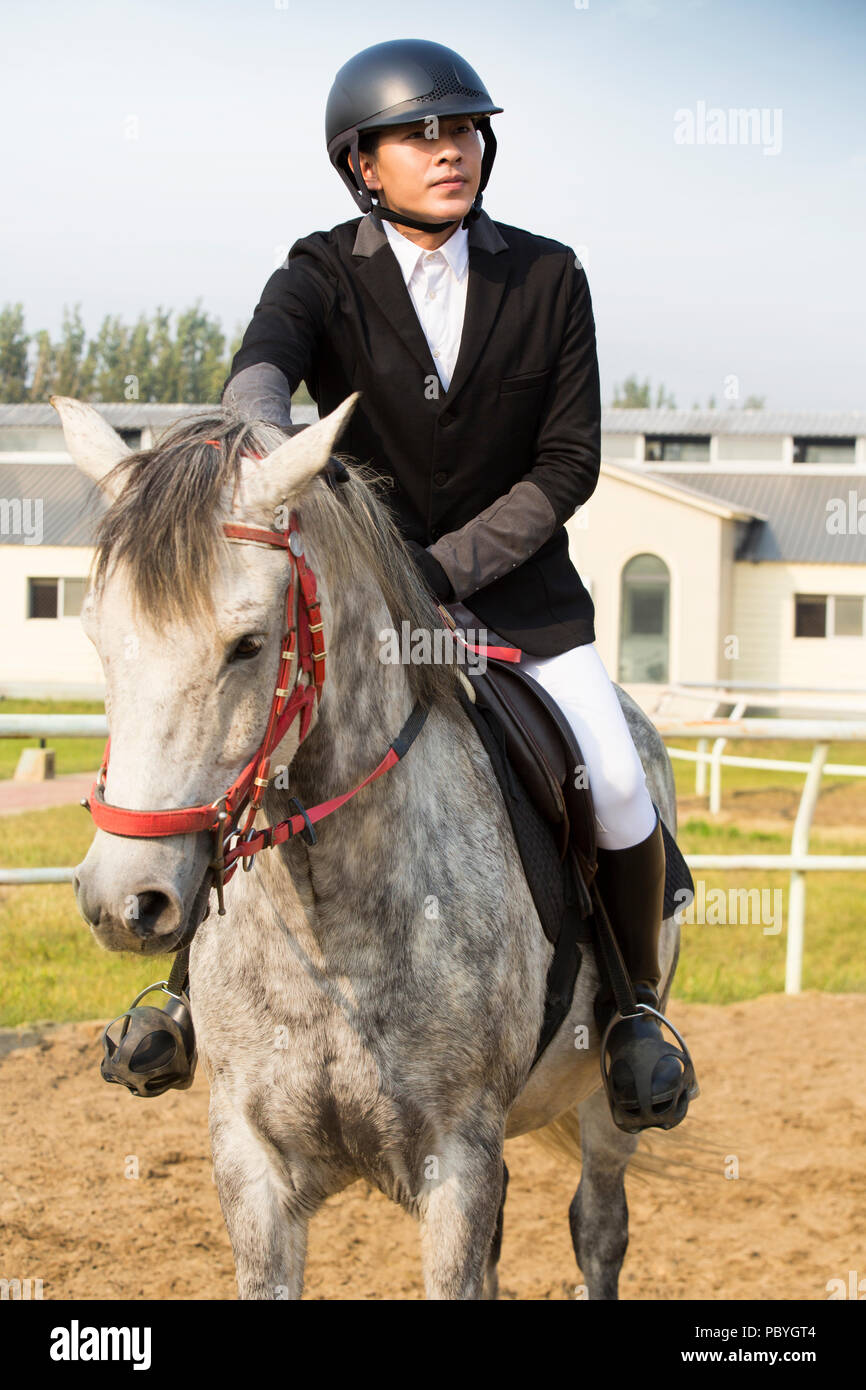 Young Chinese man riding horse Stock Photo - Alamy
