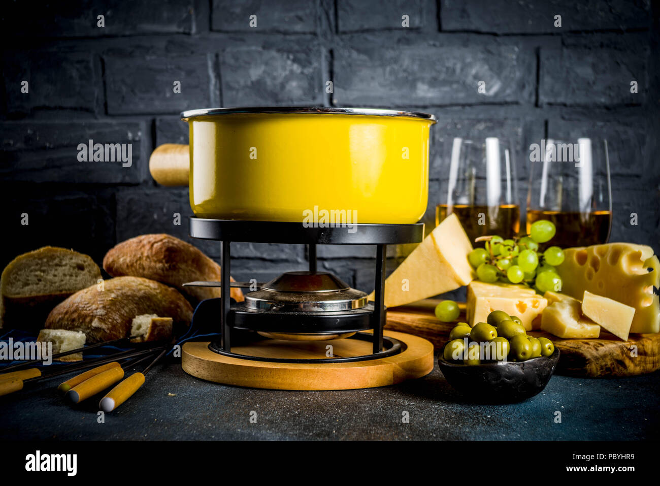 Gourmet Swiss fondue in traditional fondue pot, with forks, various ...