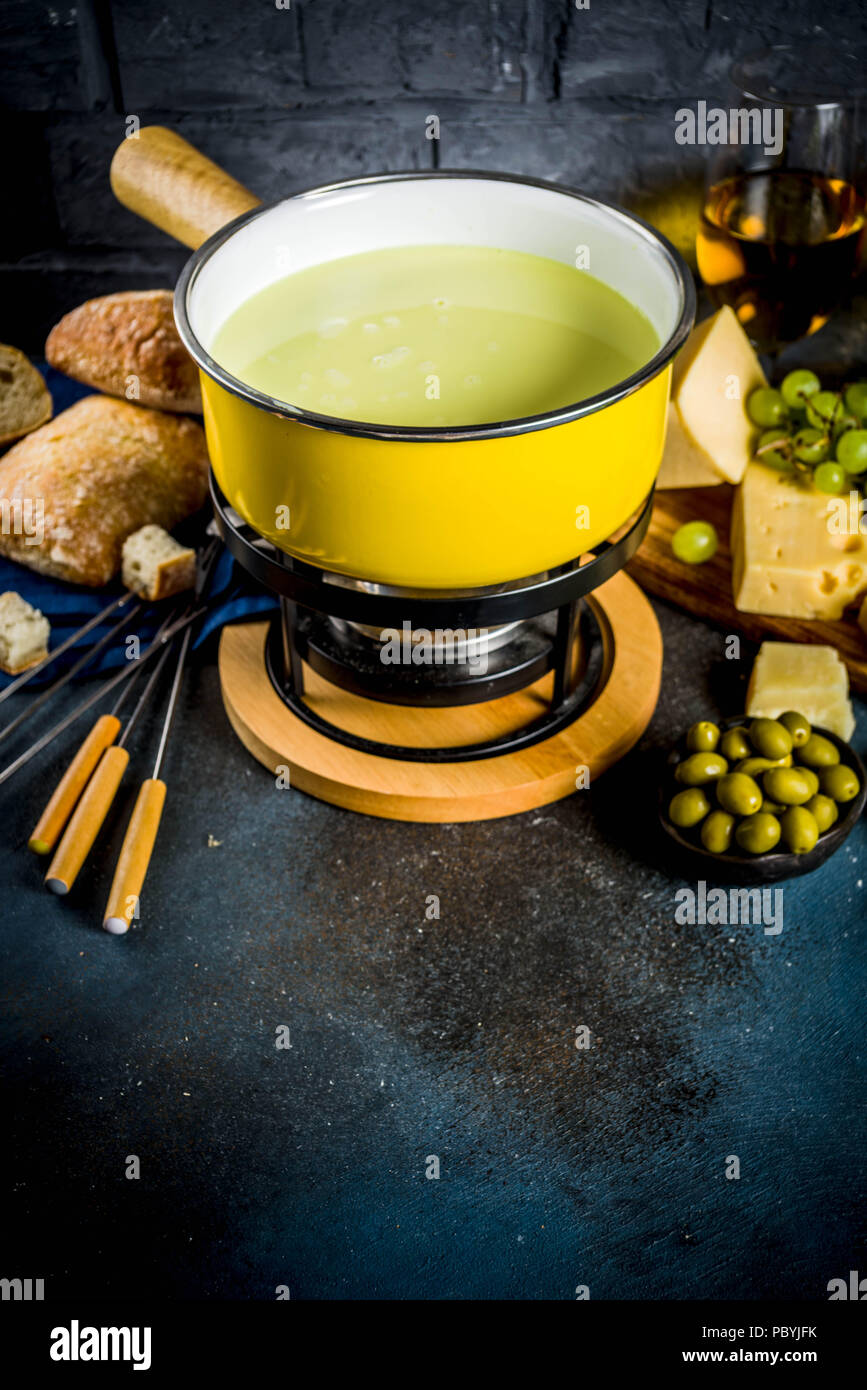 Gourmet Swiss fondue in traditional fondue pot, with forks, various ...