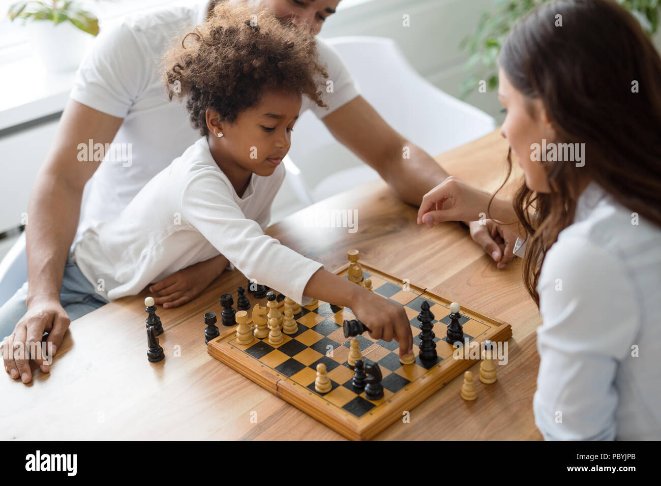 Happy family playing chess together at home Stock Photo - Alamy