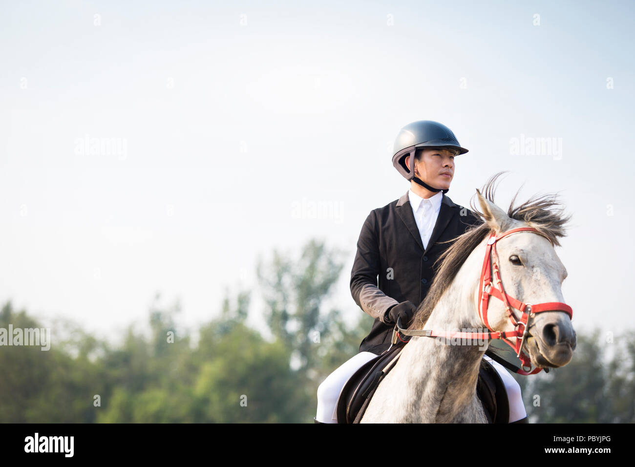 Young Chinese man riding horse Stock Photo - Alamy
