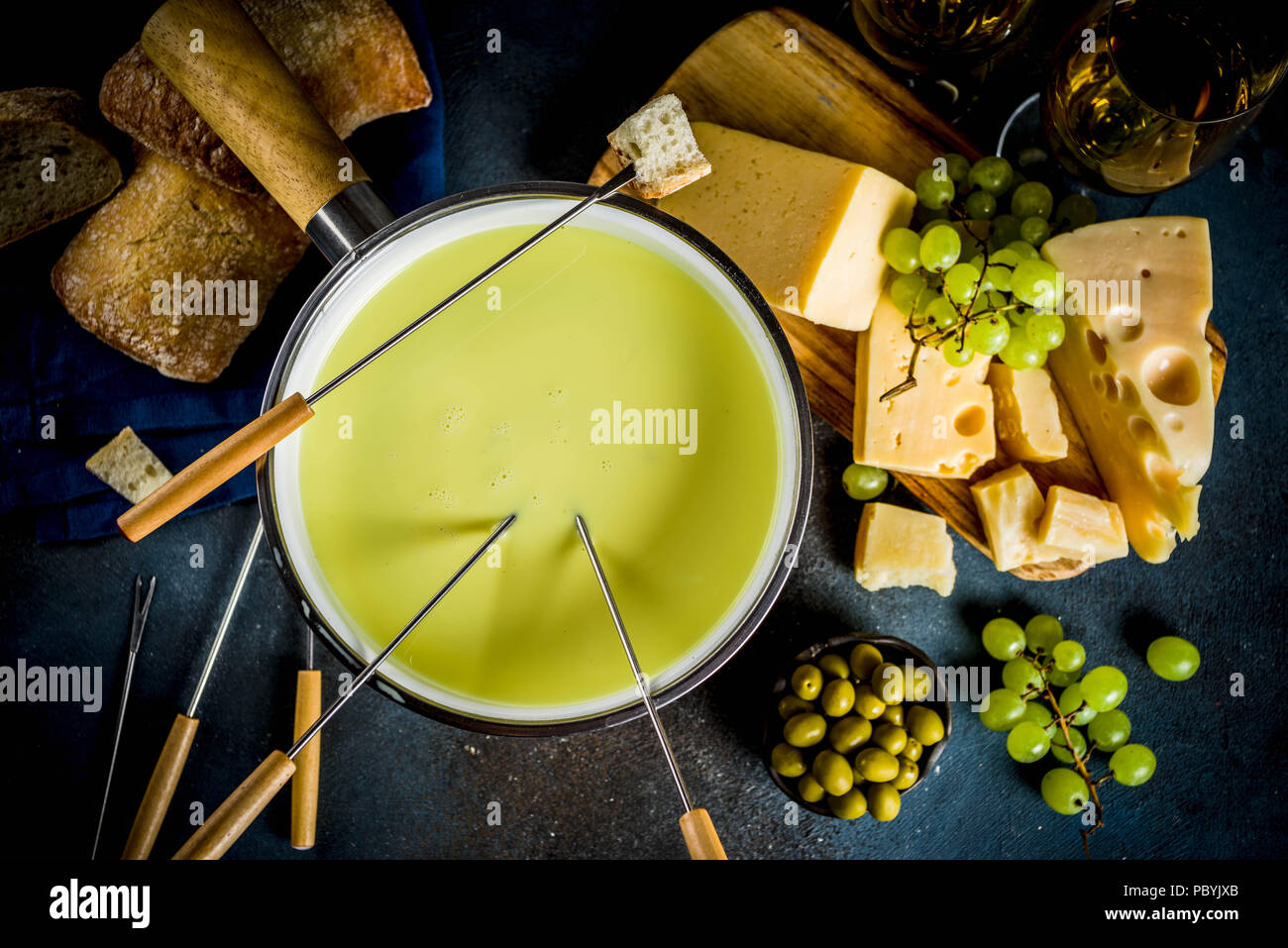 Gourmet Swiss fondue in traditional fondue pot, with forks, various ...