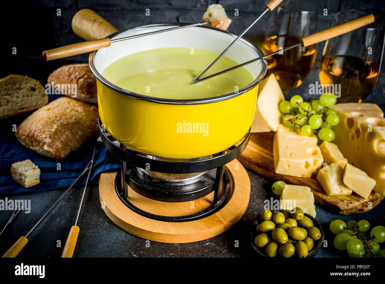 Gourmet Swiss fondue in traditional fondue pot, with forks, various ...