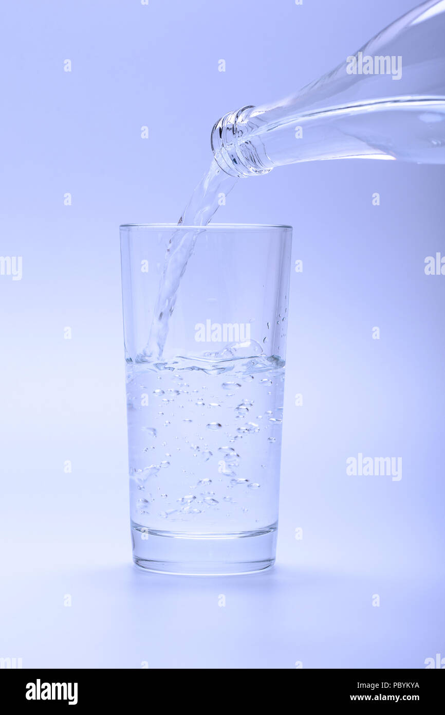 Cold fresh water pouring into a glass from a bottle Stock Photo - Alamy