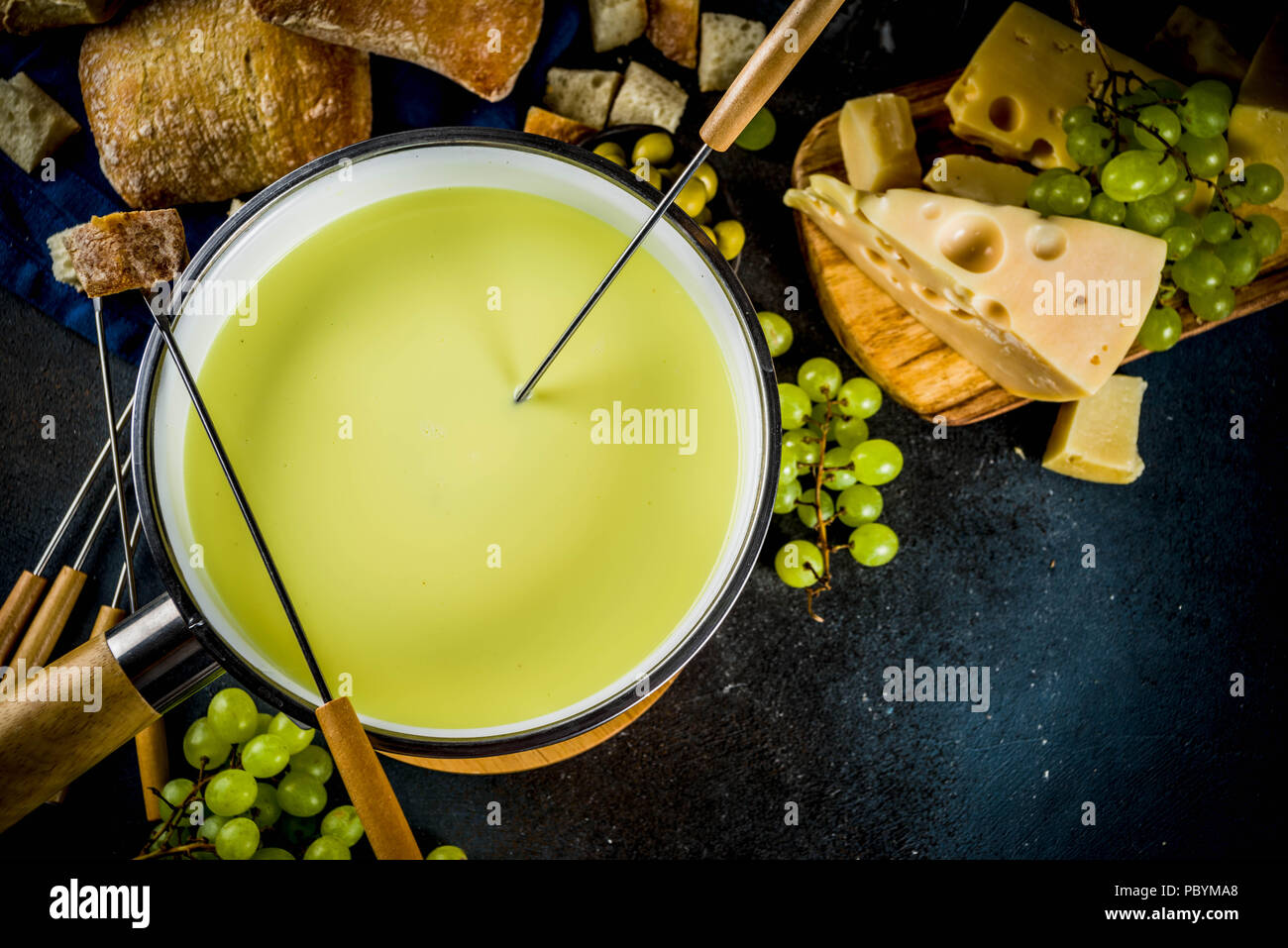 Gourmet Swiss fondue in traditional fondue pot, with forks, various ...