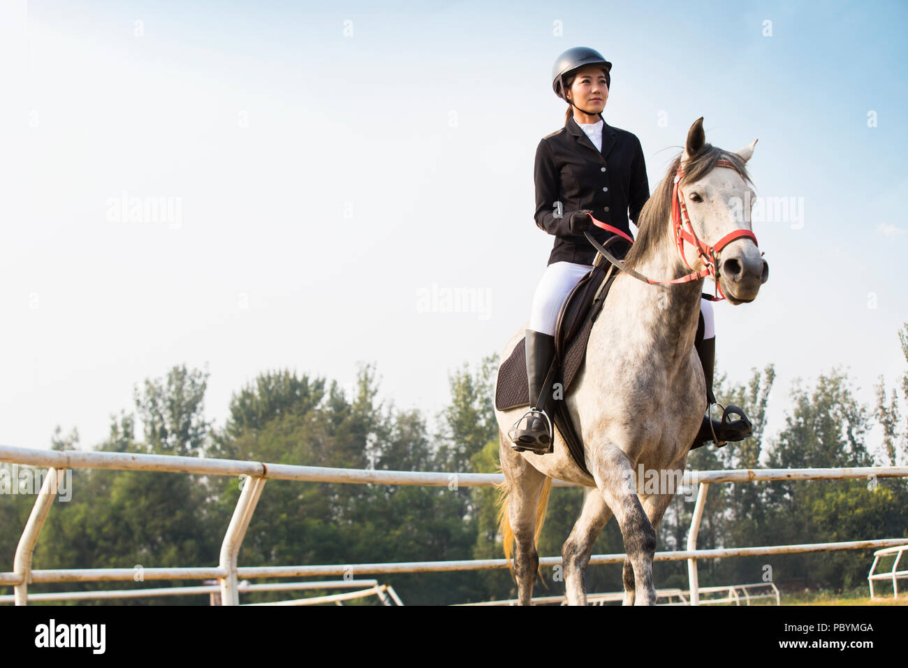 Young Chinese woman riding horse Stock Photo - Alamy