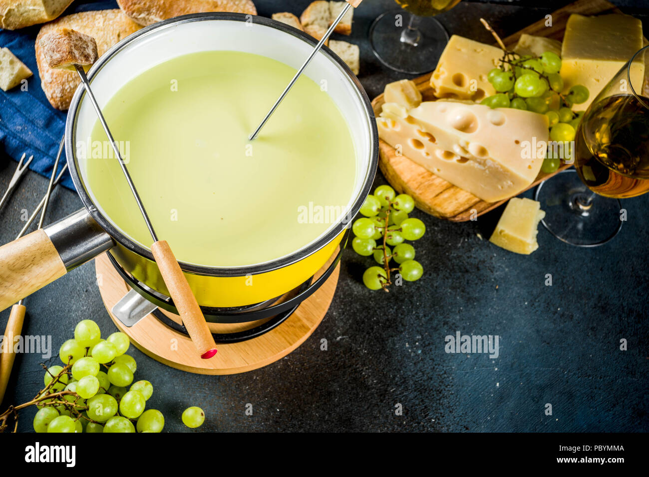Gourmet Swiss fondue in traditional fondue pot, with forks, various ...