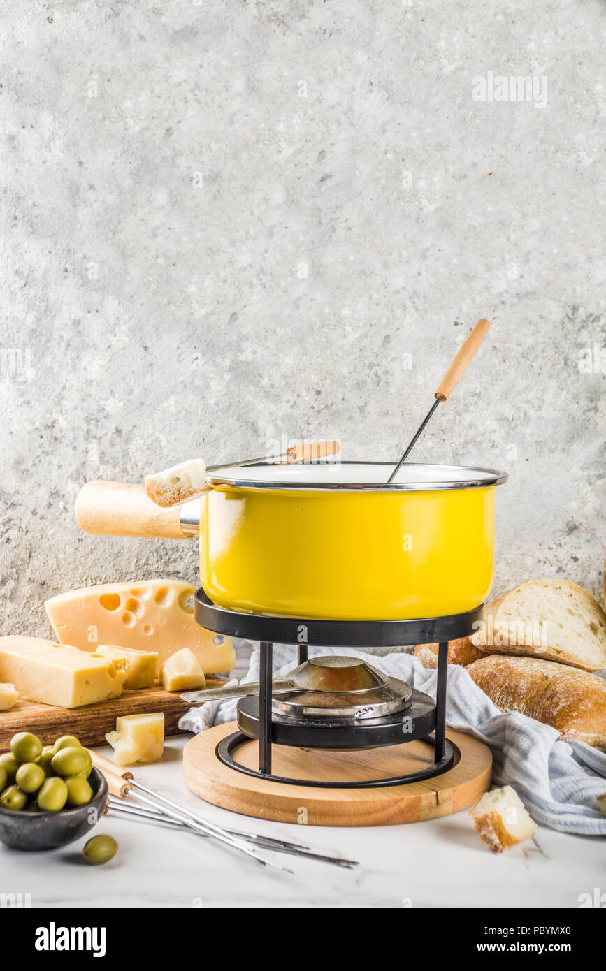 Gourmet Swiss fondue in traditional fondue pot, with forks, various ...
